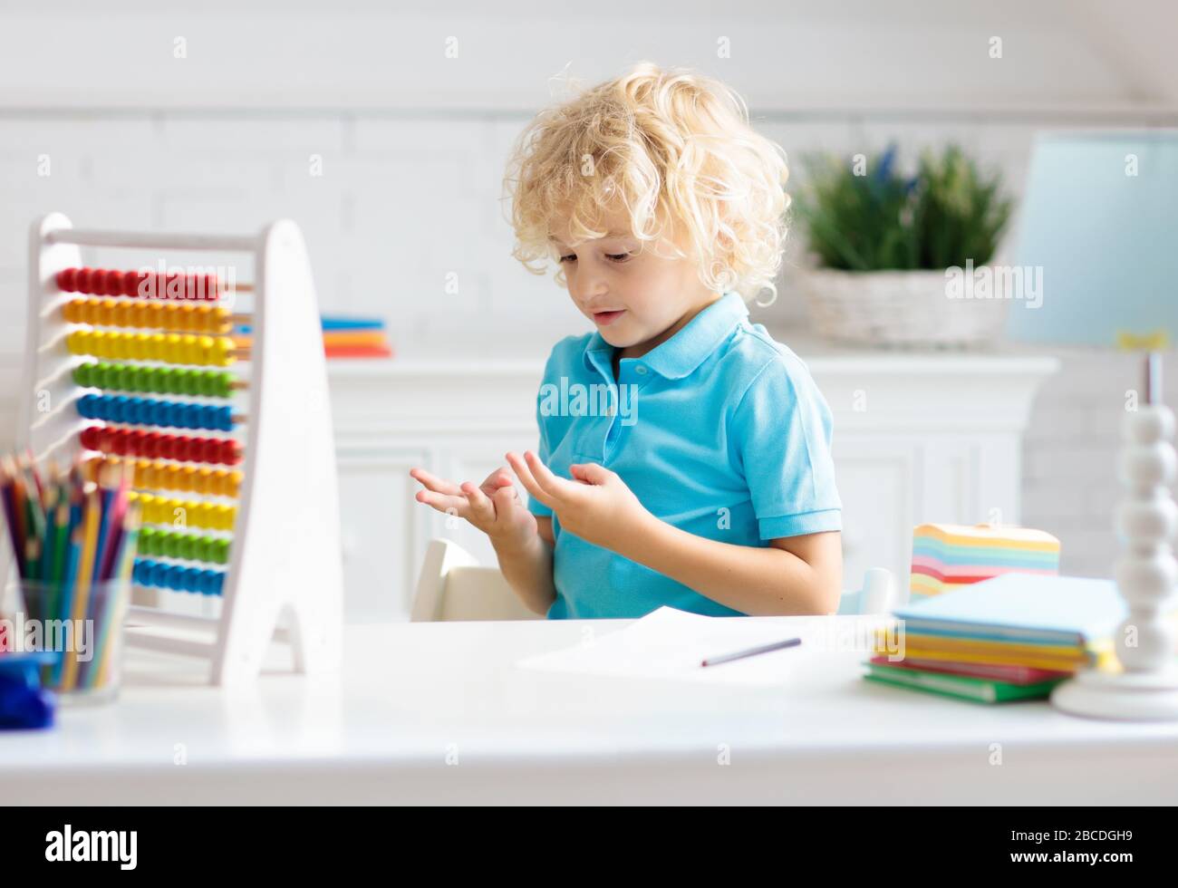 Child doing homework at home. Little boy with wooden colorful abacus ...
