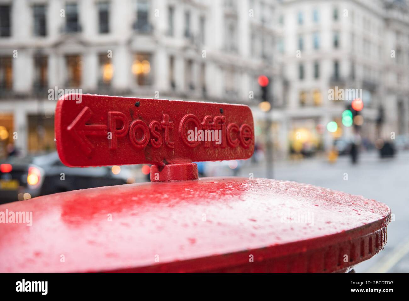 English red mailbox sending a letter in a busy London street Stock ...