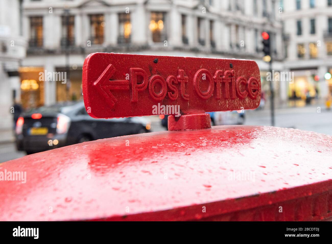 English red mailbox sending a letter in a busy London street Stock ...
