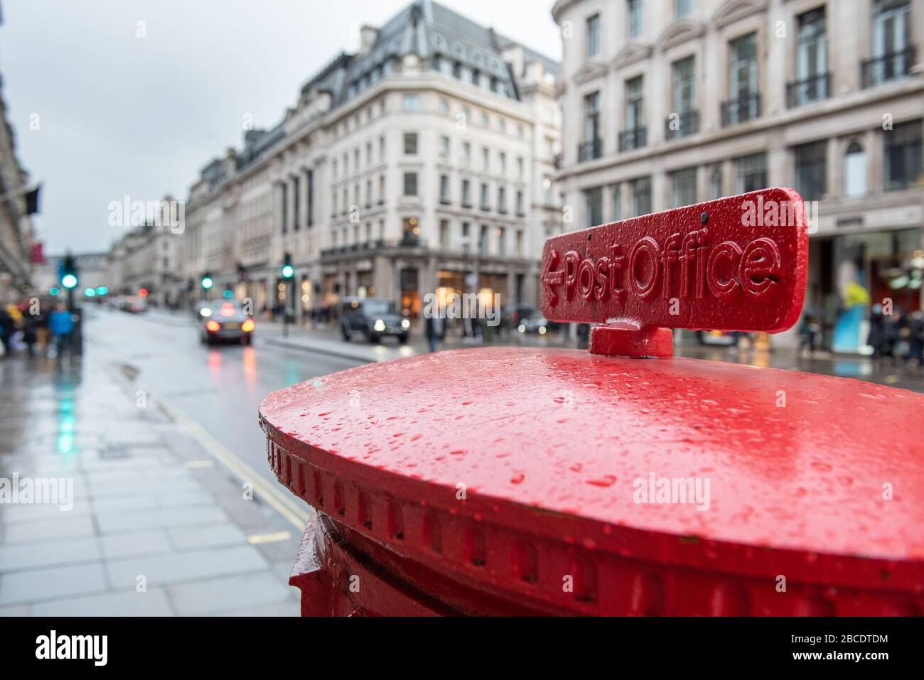English red mailbox sending a letter in a busy London street Stock ...