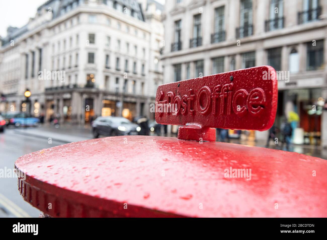 English red mailbox sending a letter in a busy London street Stock ...