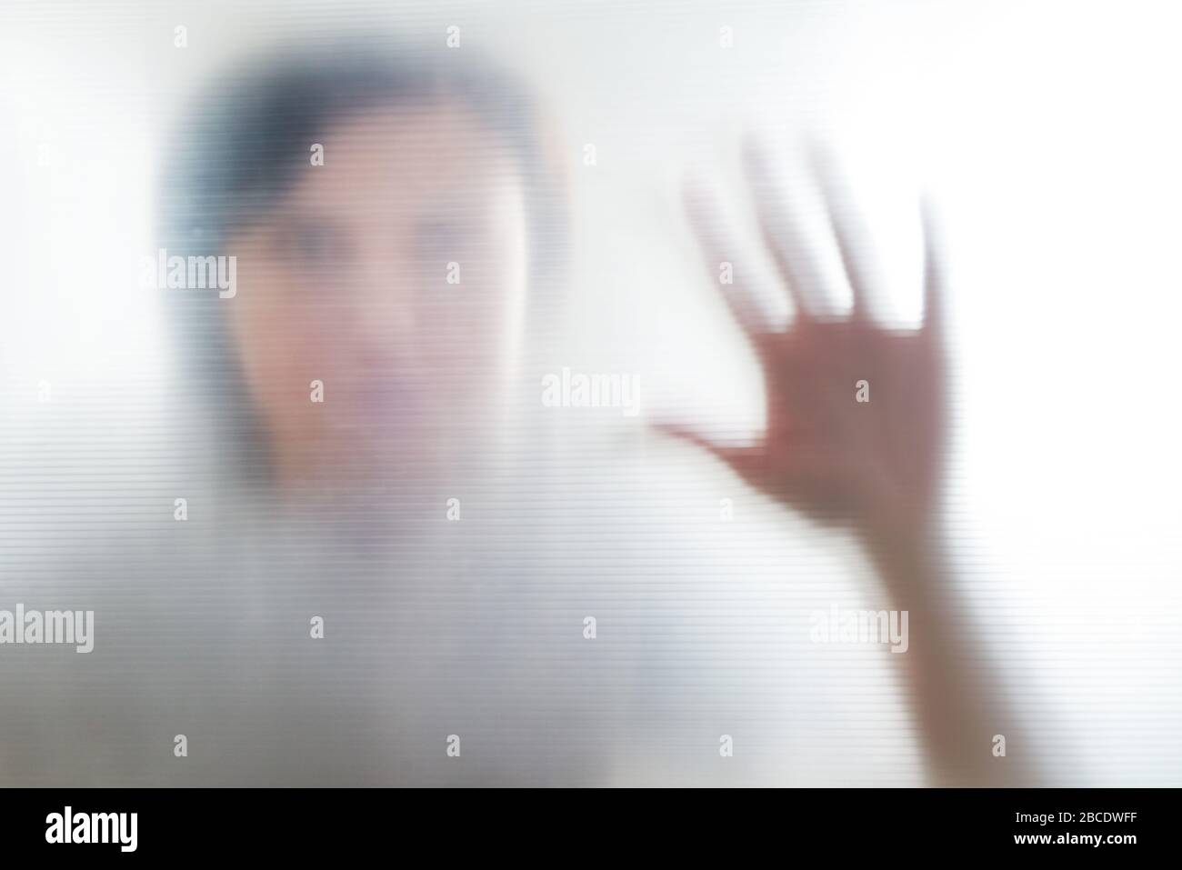 Diffused silhouette of female hands, view with shadow through plastic ...