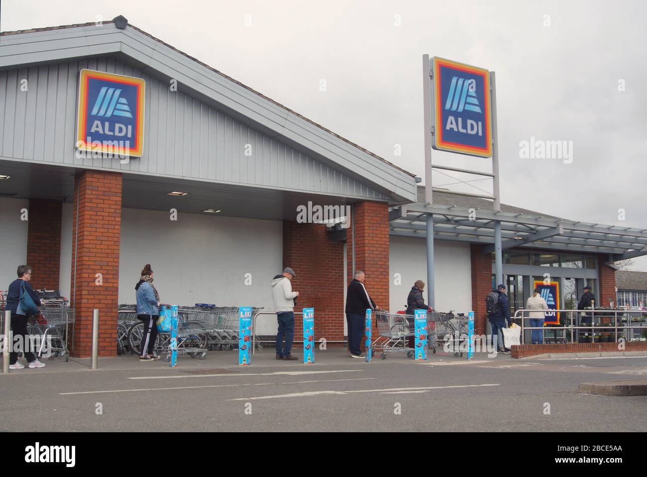 people social distancing in a queue outside Aldi supermarket during the ...