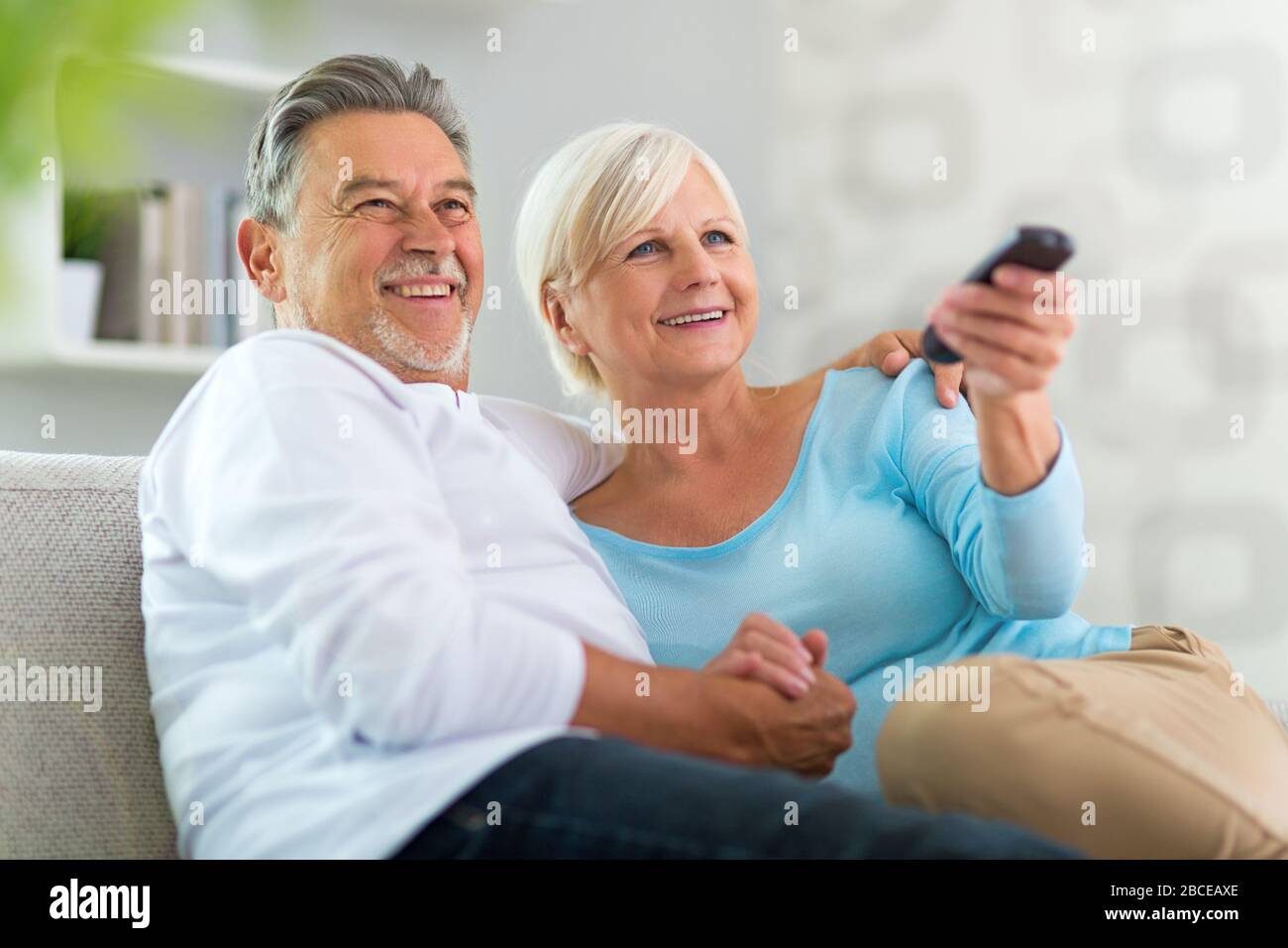 Senior couple with remote control Stock Photo - Alamy