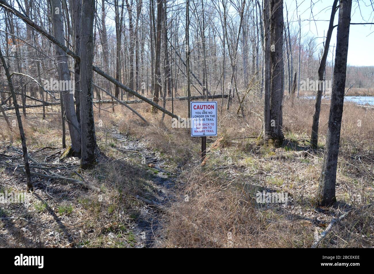 caution you are no longer on the nature trail sign and trees in forest ...
