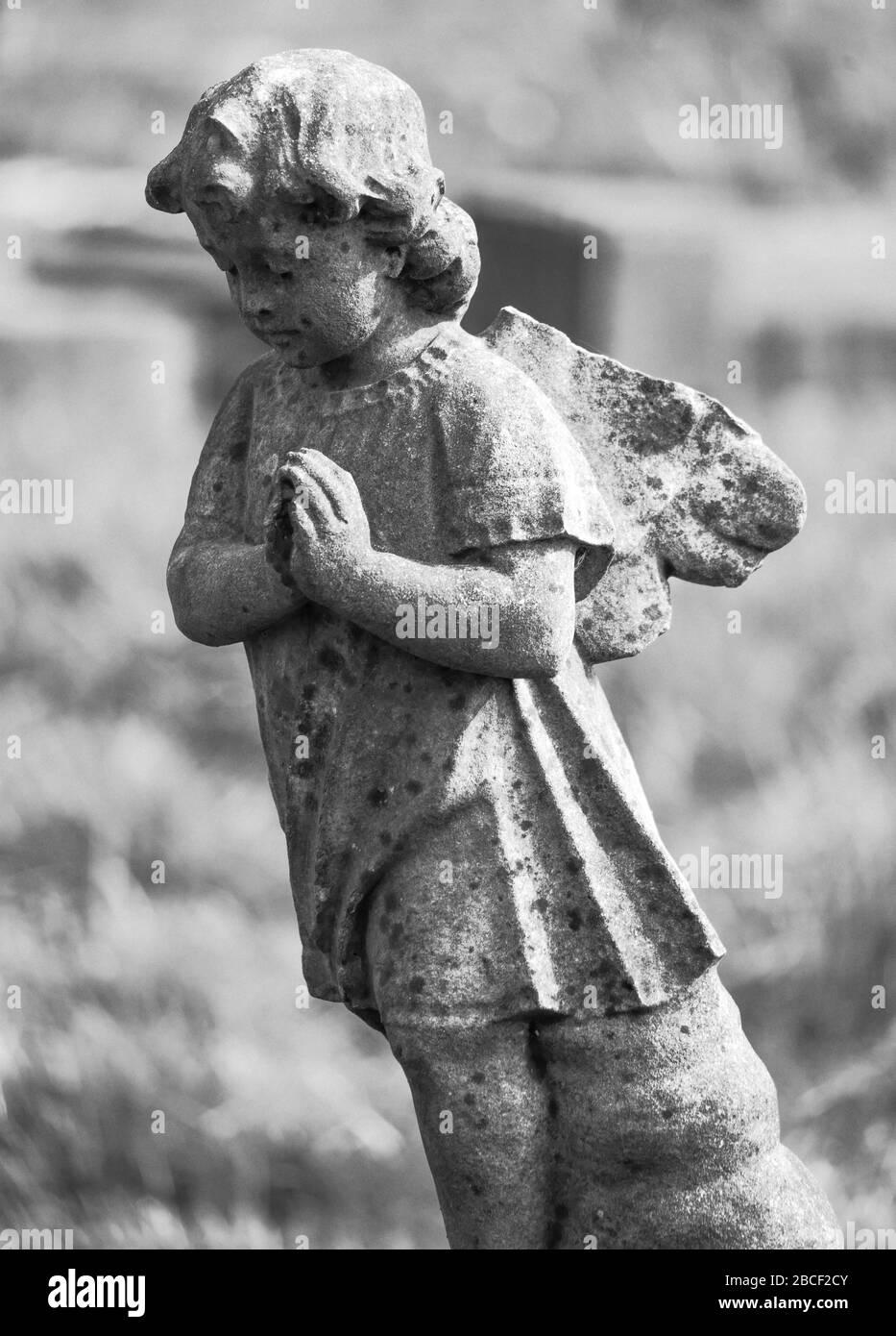 A black and white photo of a Christian cherub gravestone in a graveyard ...