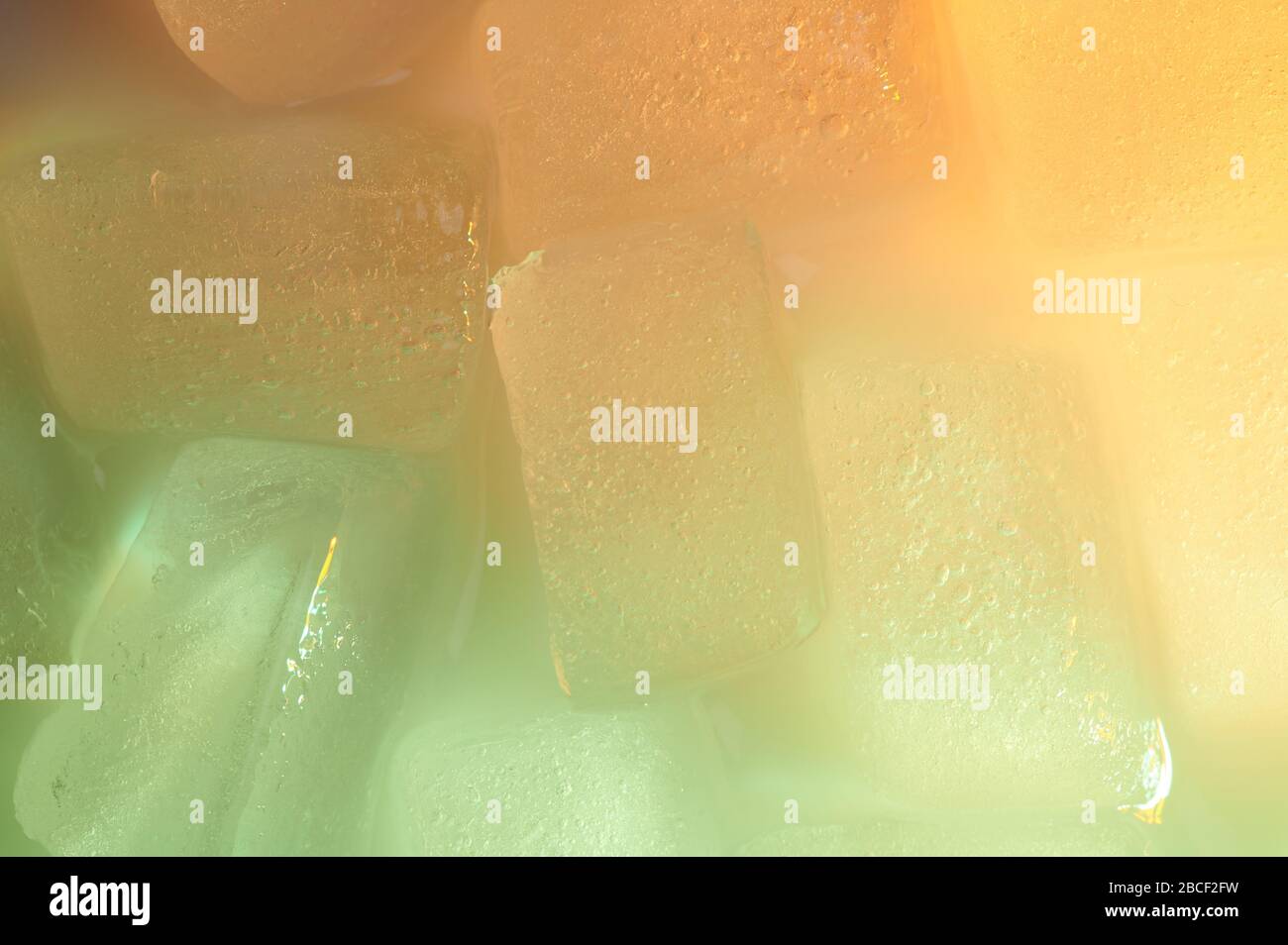 Orange and green color ice cubes background close up view Stock Photo ...