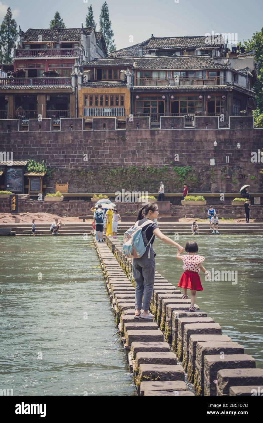 Feng Huang, China - August 2019 : Mother and daughter crossing waters ...