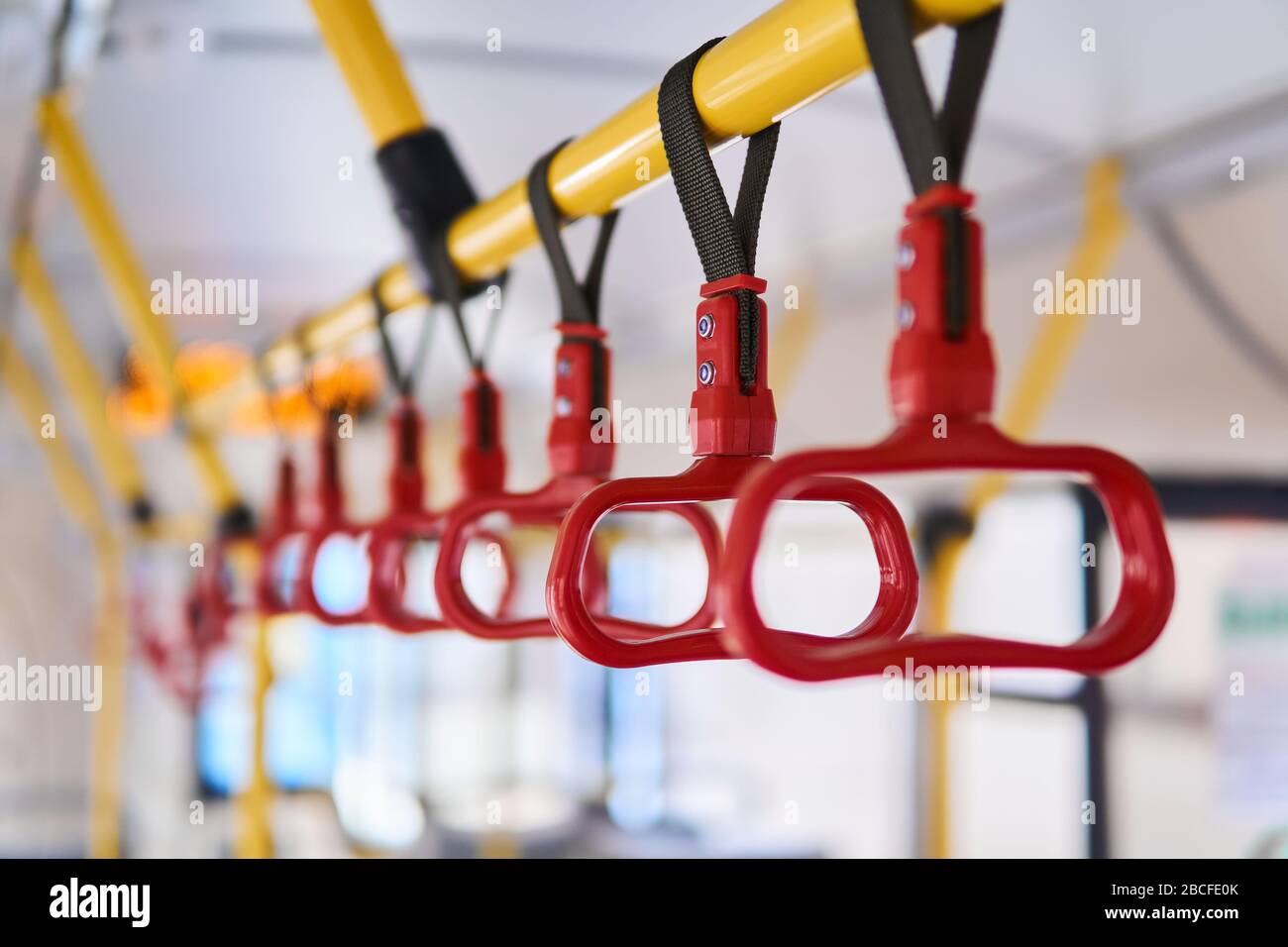 partially blurred row of grab handles for standing passengers in the ...
