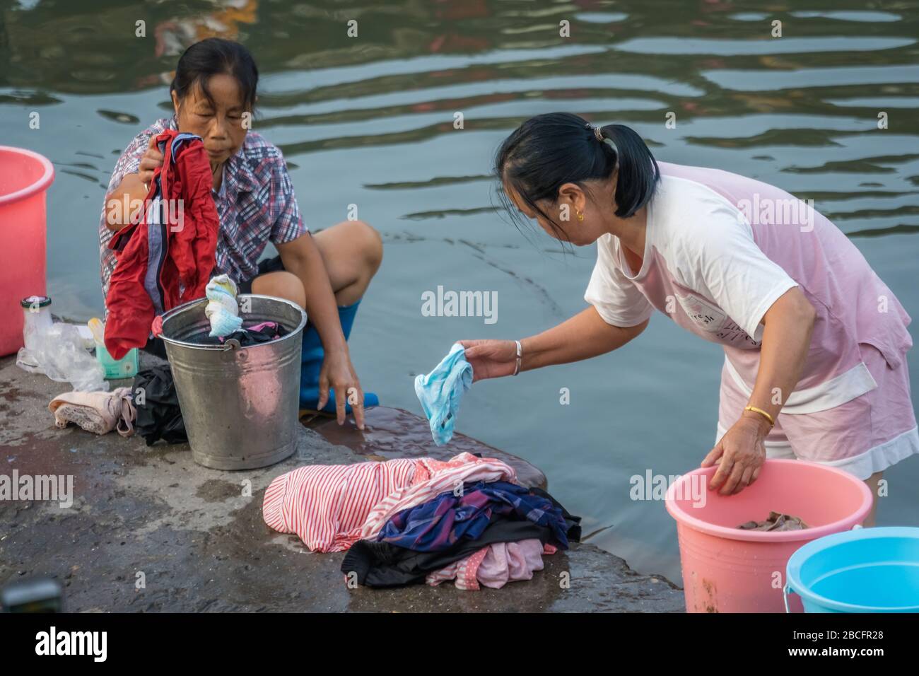 Feng Huang, China - August 2019 : Chinese women doing laundry on the ...