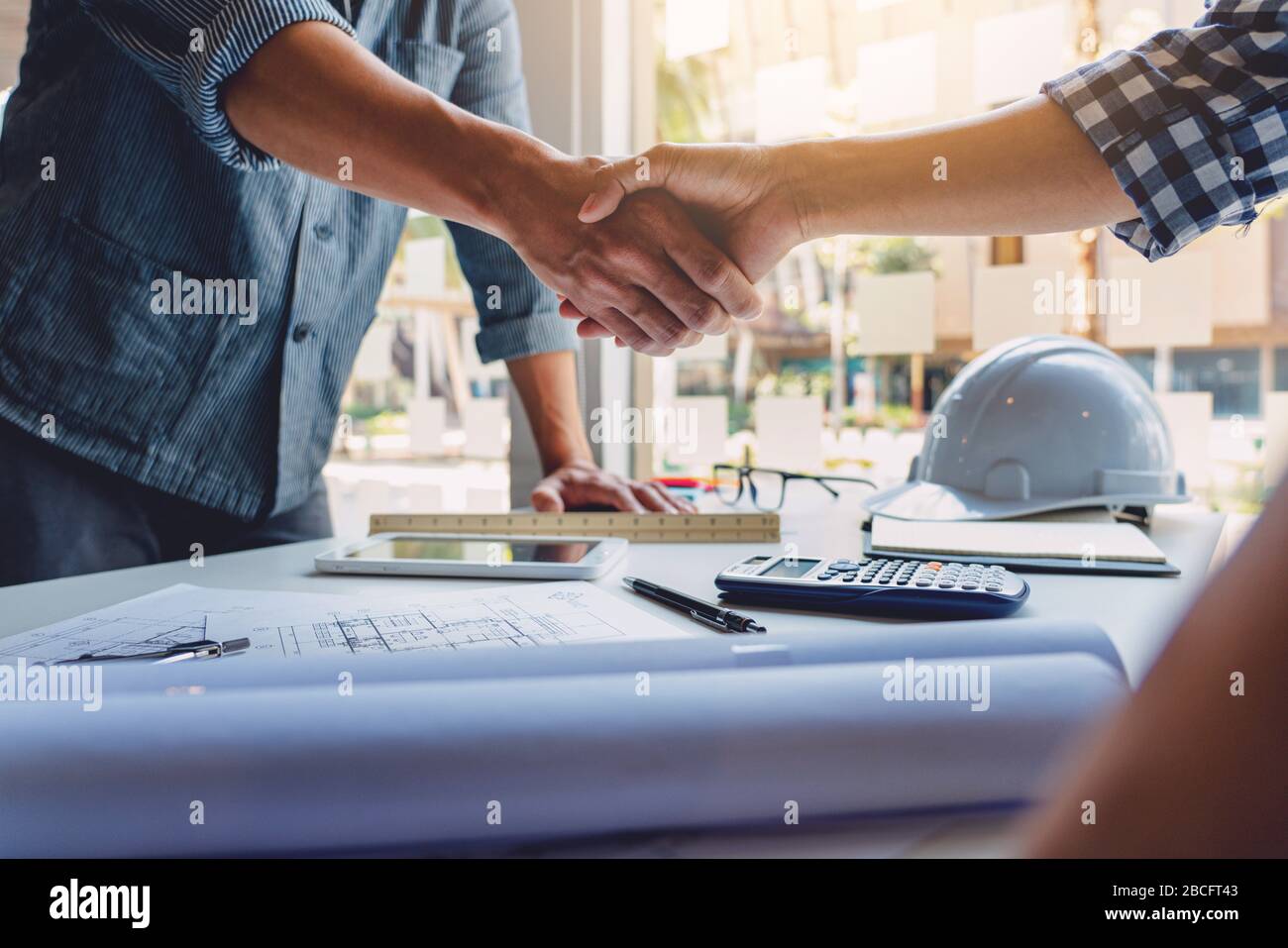 Architect and engineer construction workers shaking hands while working ...
