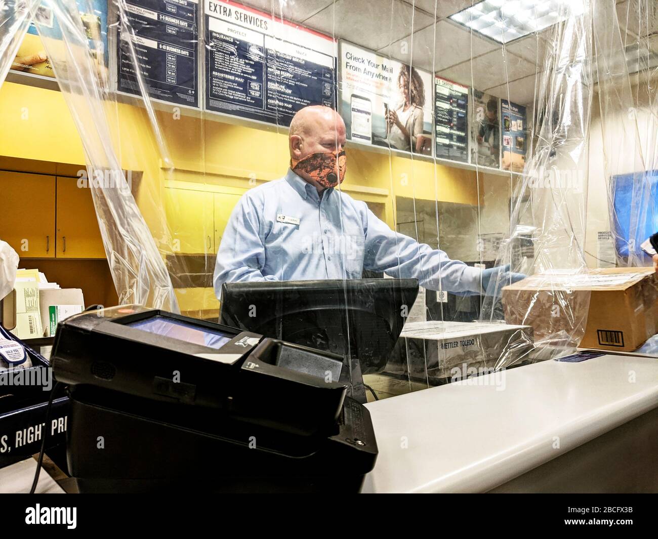 Postal workers wearing gloves and masks deliver the mail rain or shine ...