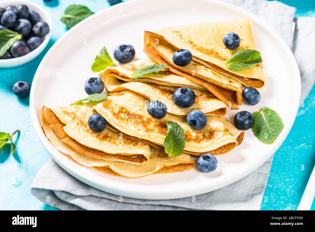Crepes with blueberries at blue table Stock Photo - Alamy