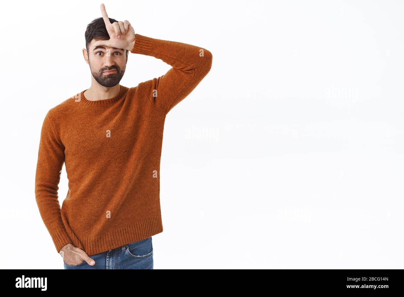 Portrait of funny handsome bearded man look gloomy, showing loser sign ...