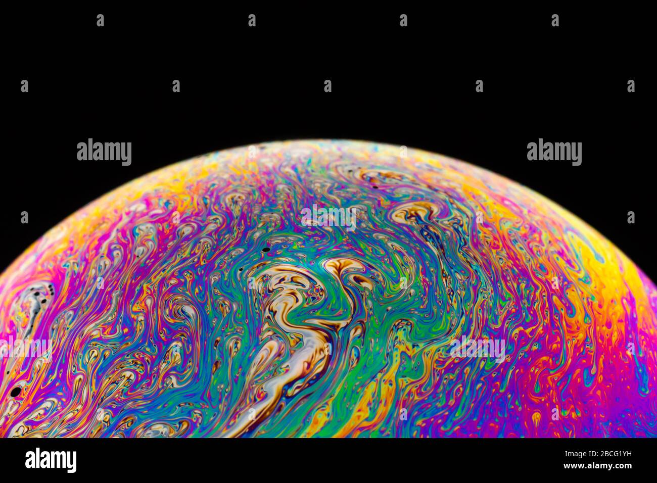 Macrophotograph of a colorful soap bubble that look like a planet in ...