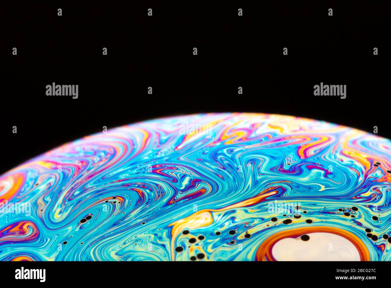 Macrophotograph of a colorful soap bubble that look like a planet in ...