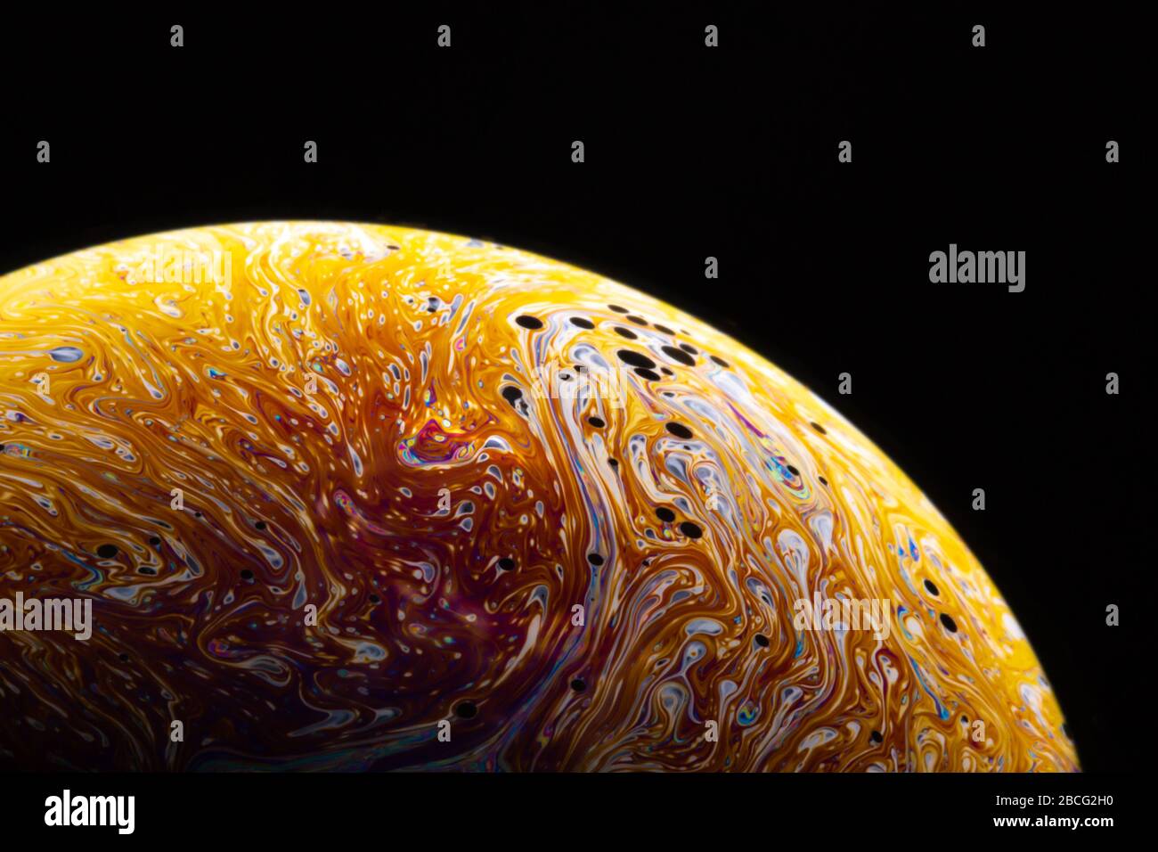 Macrophotograph of a colorful soap bubble that look like a planet in ...