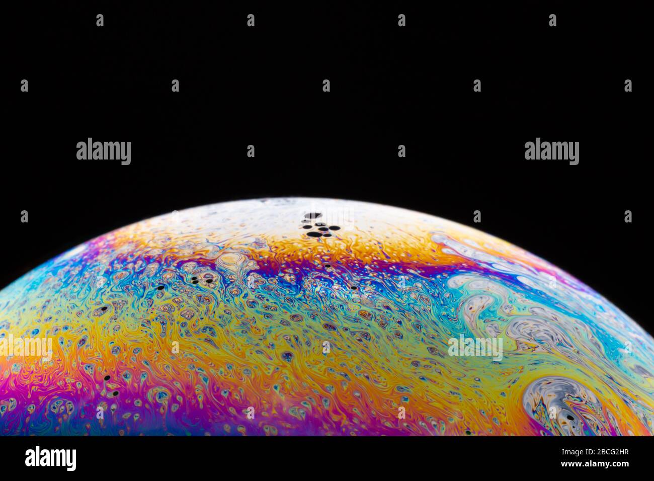 Macrophotograph of a colorful soap bubble that look like a planet in ...