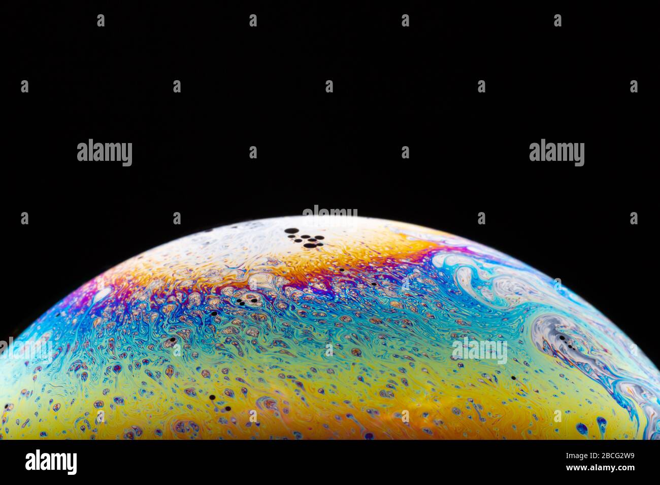 Macrophotograph of a colorful soap bubble that look like a planet in ...
