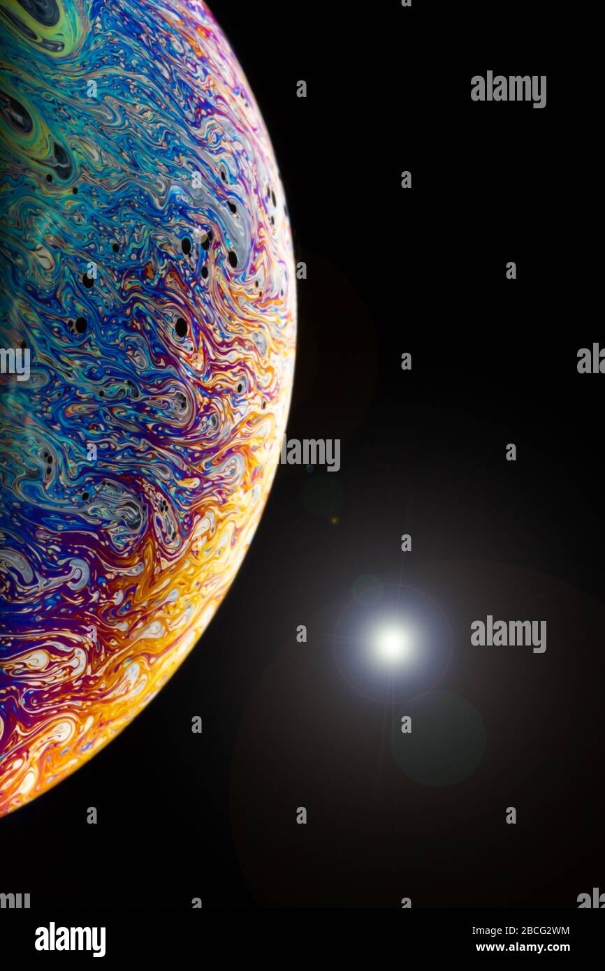 Macrophotograph of a colorful soap bubble that look like a planet in ...