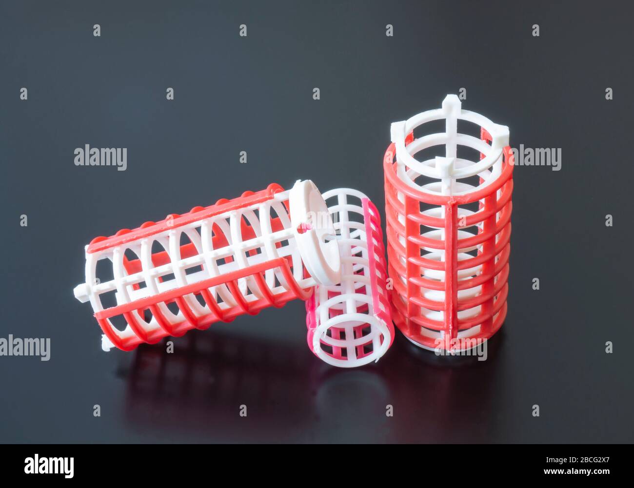 The Curlers of the rose colour on black background. Instrument for wave ...