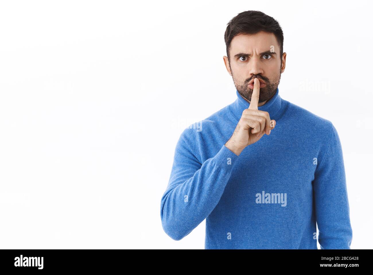 Portrait of serious-looking strict boss shushing at person talking ...
