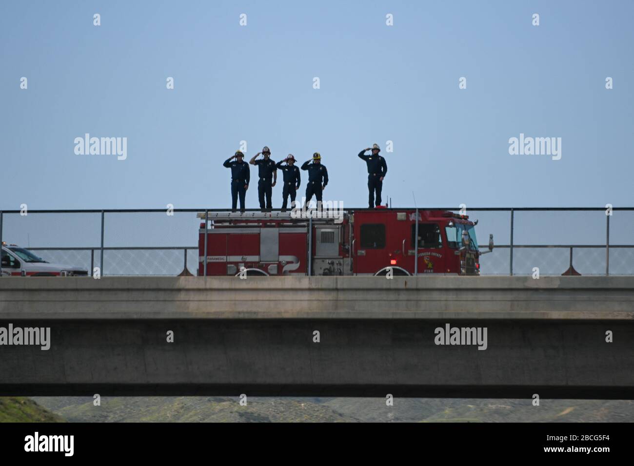 Riverside, California, USA. 3rd Apr 2020. Firefighters stand atop their ...