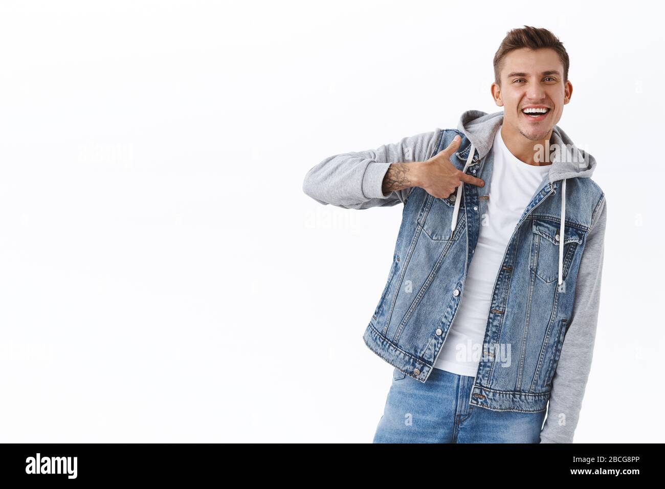 Handsome proud and boastful blond guy with huge ego pointing at himself ...