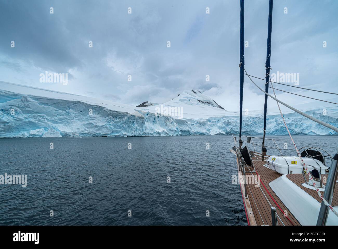 sailing boat in Antarctica, yacht navigation through icebergs and sea ...