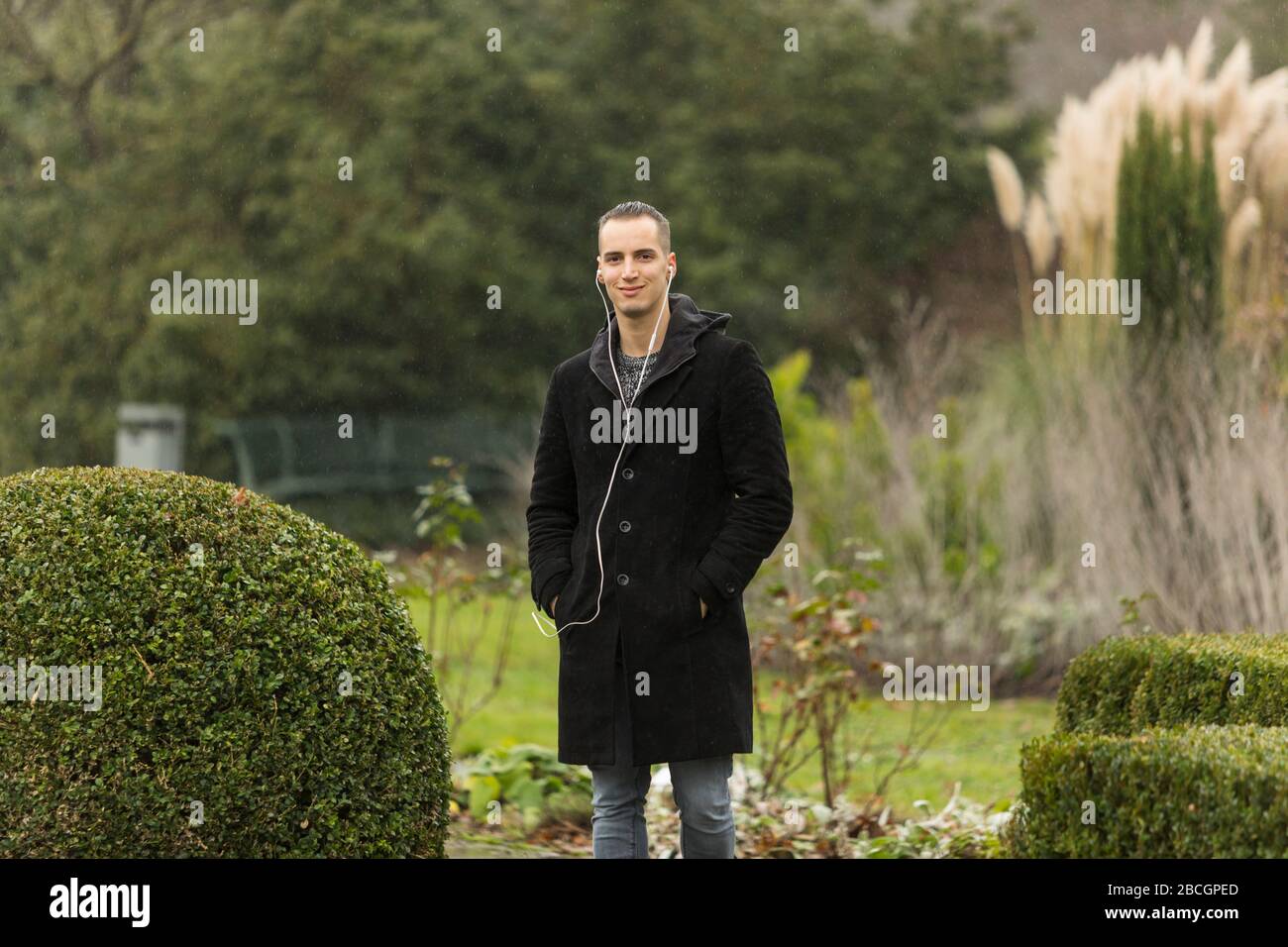 Portrait of Young Man Standing in Topiary Garden Stock Photo - Alamy