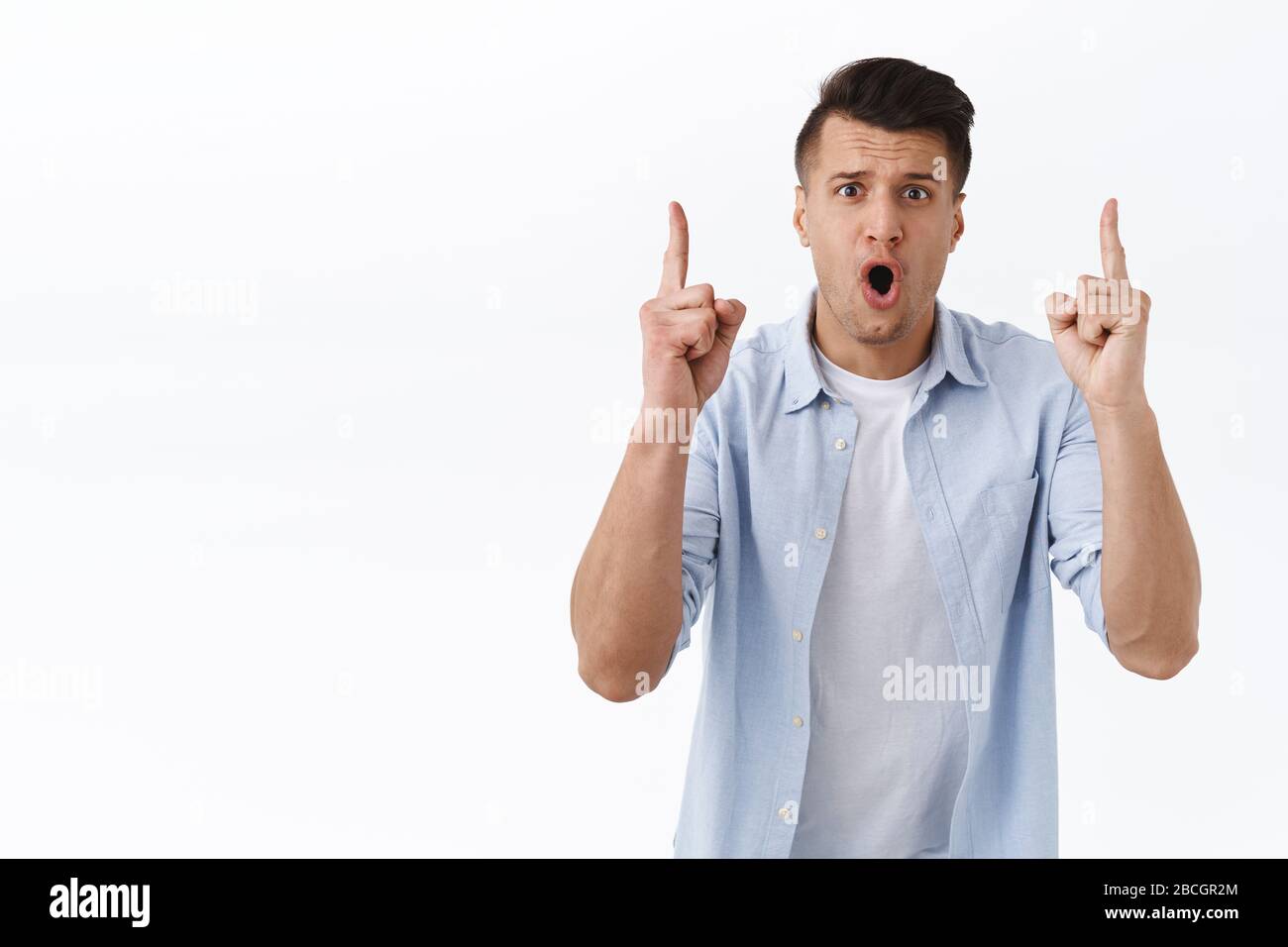 Portrait of alarmed and thrilled young concerned man showing something ...