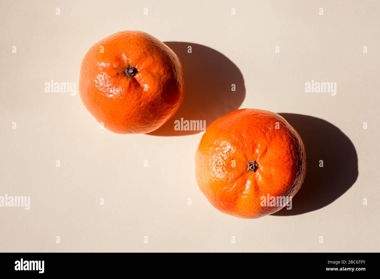 Two oranges with shadow on a plain background Stock Photo - Alamy