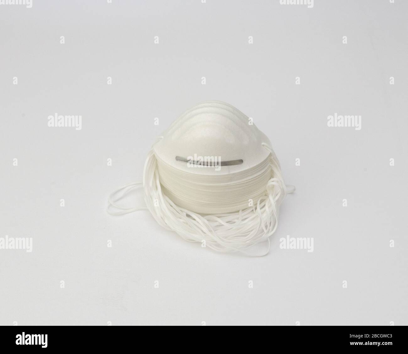 A pile of white dust masks on white background, isolated, viewed from ...