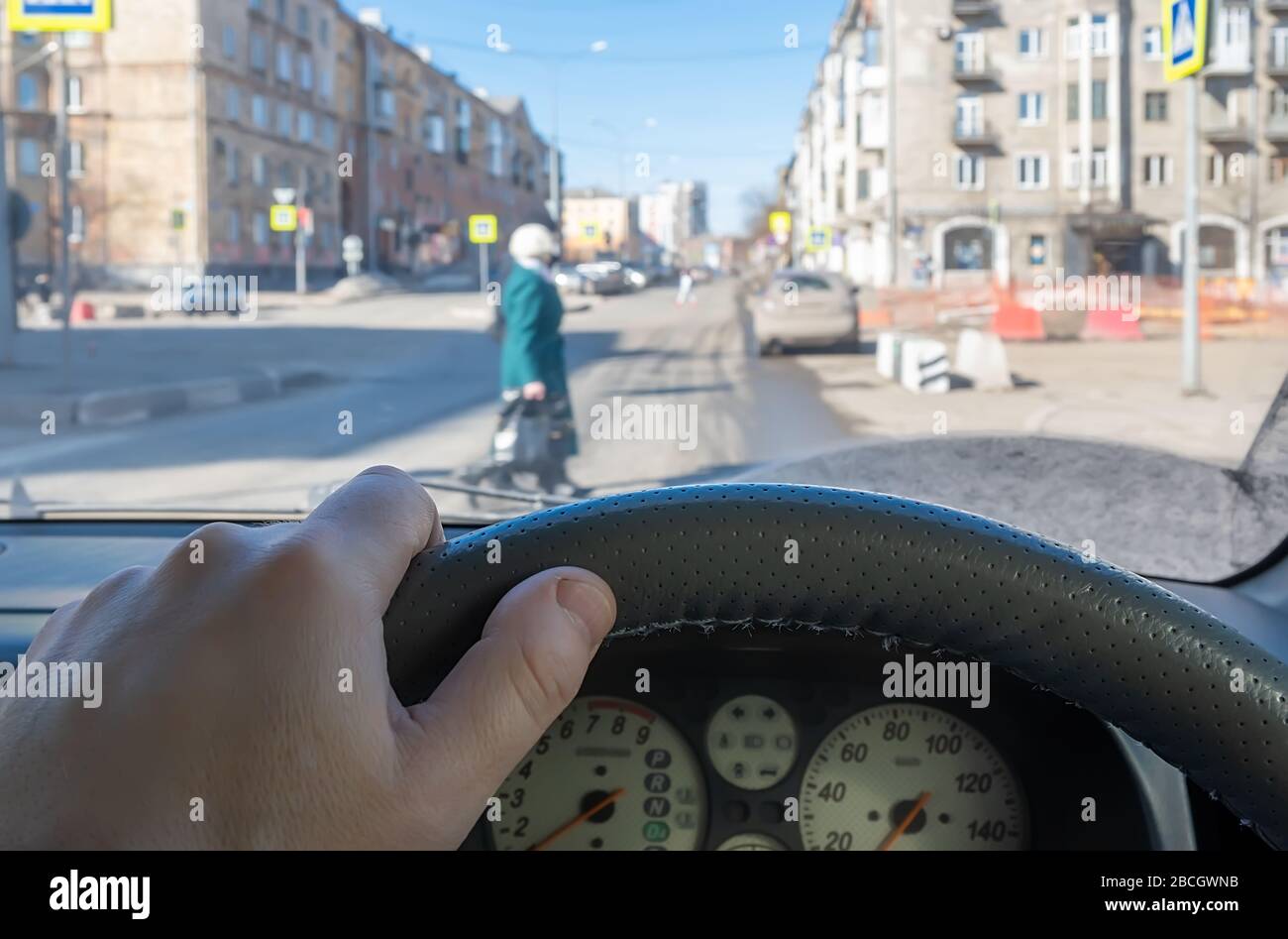 view from the car, the driver hand on the steering wheel of the car ...