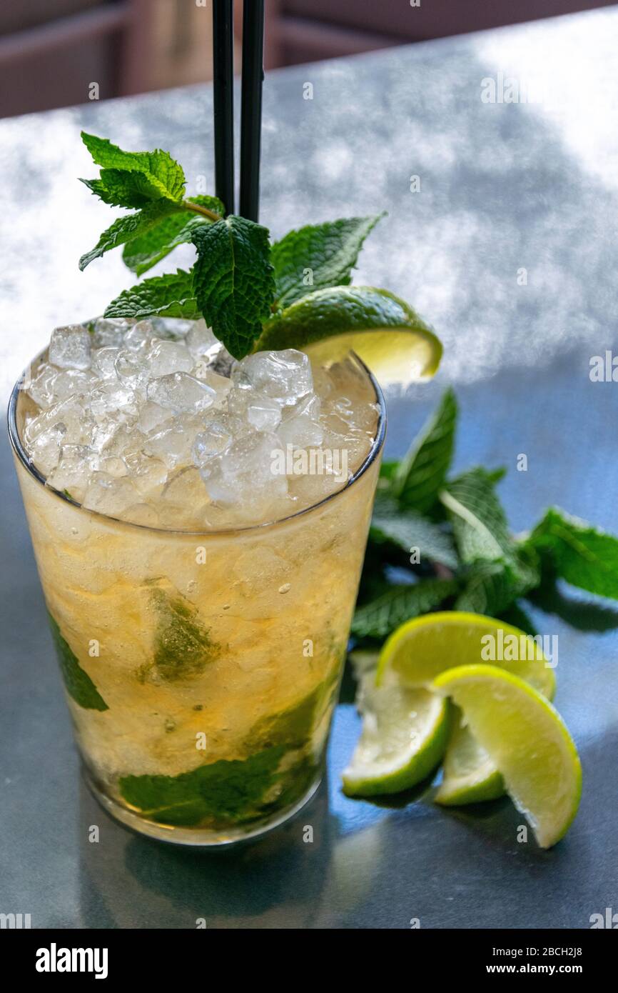 a chilled lime and mint Mojito cocktail drink with some ingredients ...
