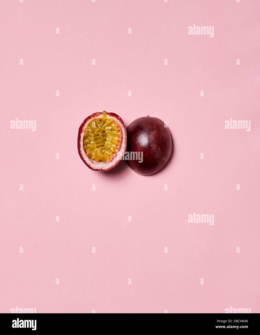 Flat lay of sliced passion fruit lying on pastel pink background Stock ...