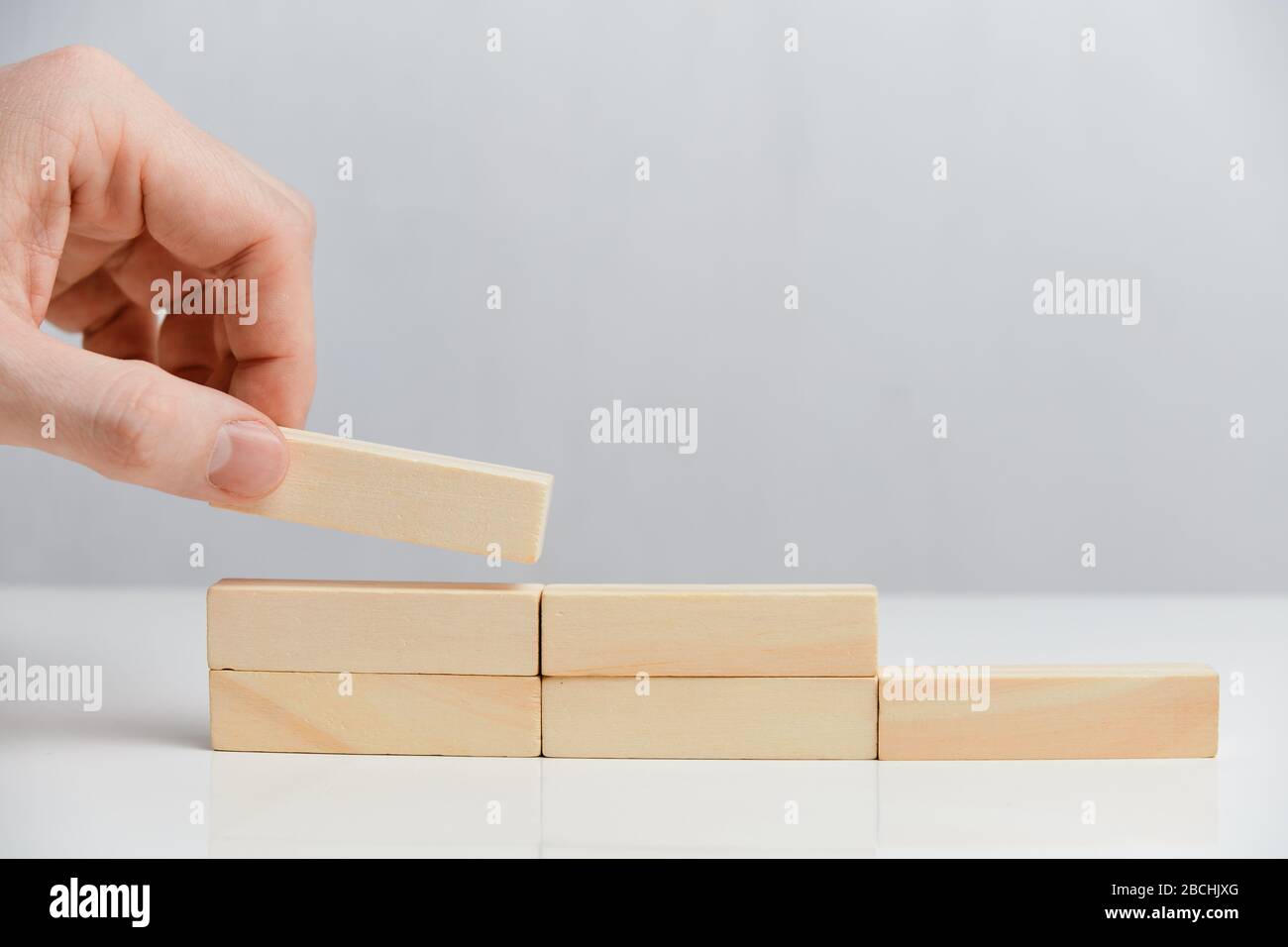 The concept of work according to plan. Hand holds wooden blocks on a ...