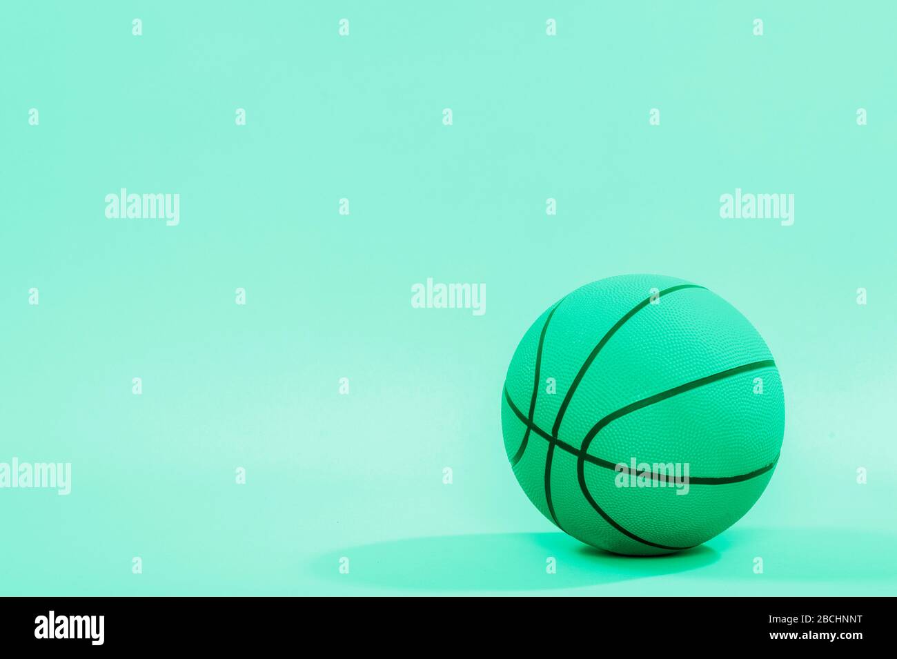Basketball ball isolated on green background Stock Photo - Alamy
