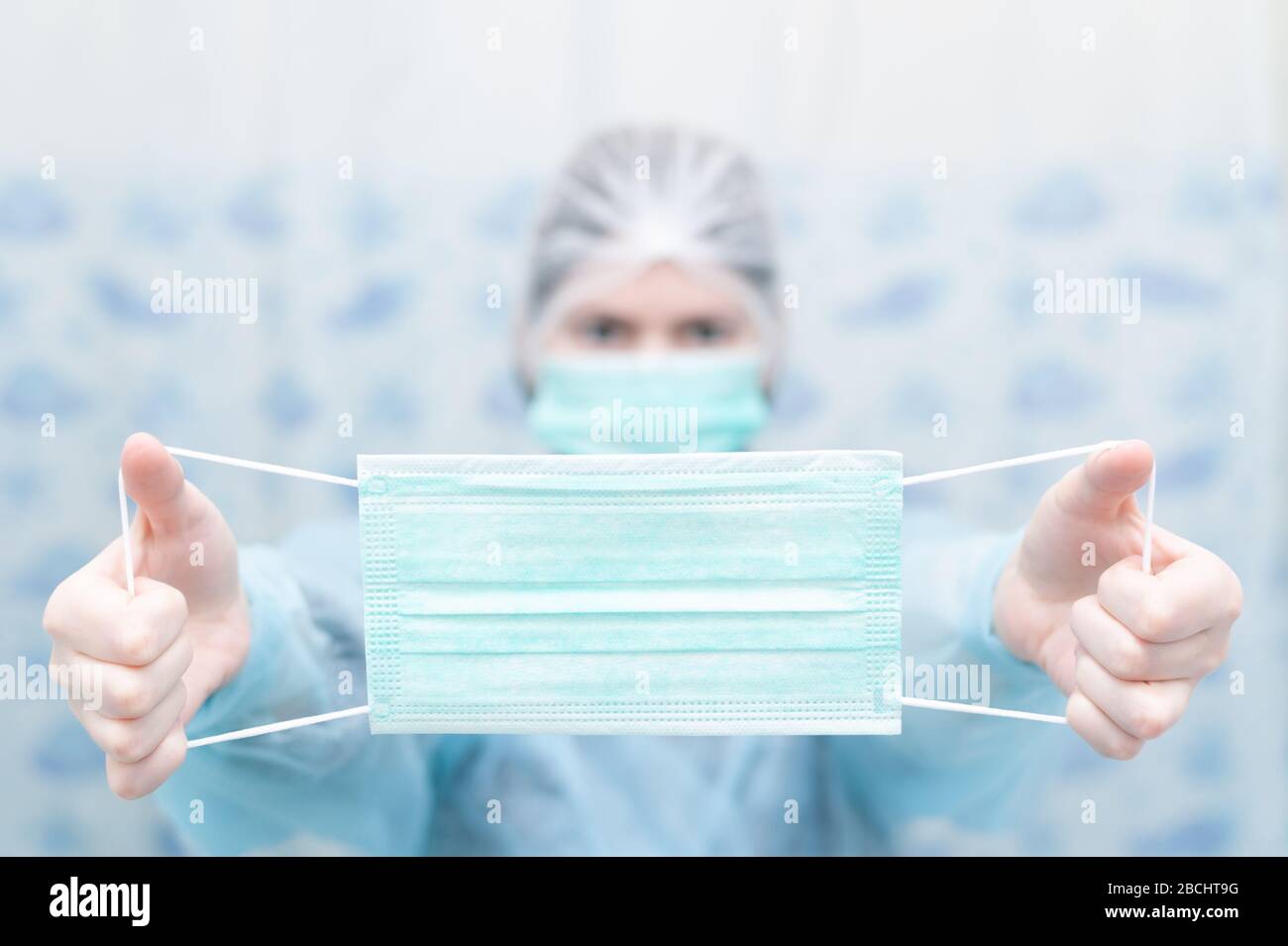 Doctor(nurse) in special suite holds a face mask as preventive measure ...