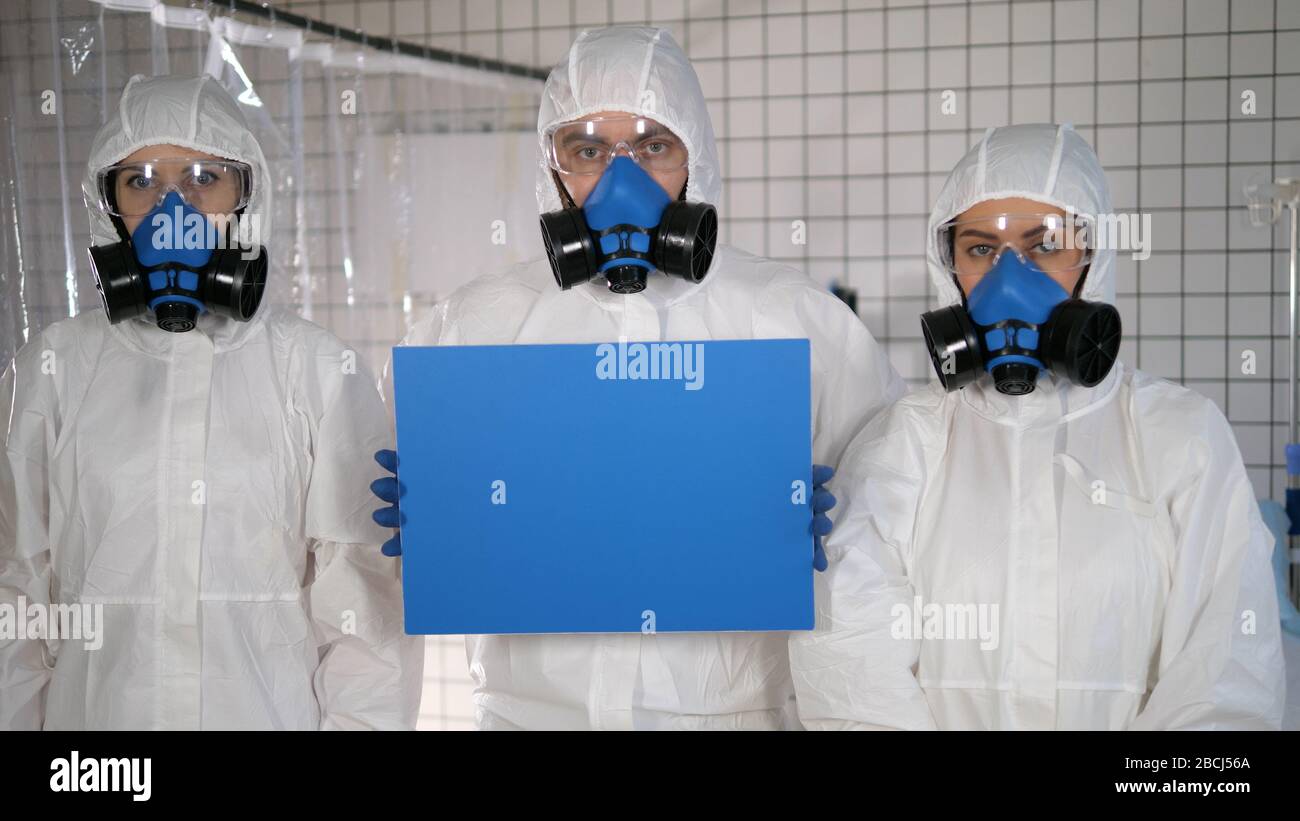 Lab scientists in safety suits holding empty board Stock Photo - Alamy