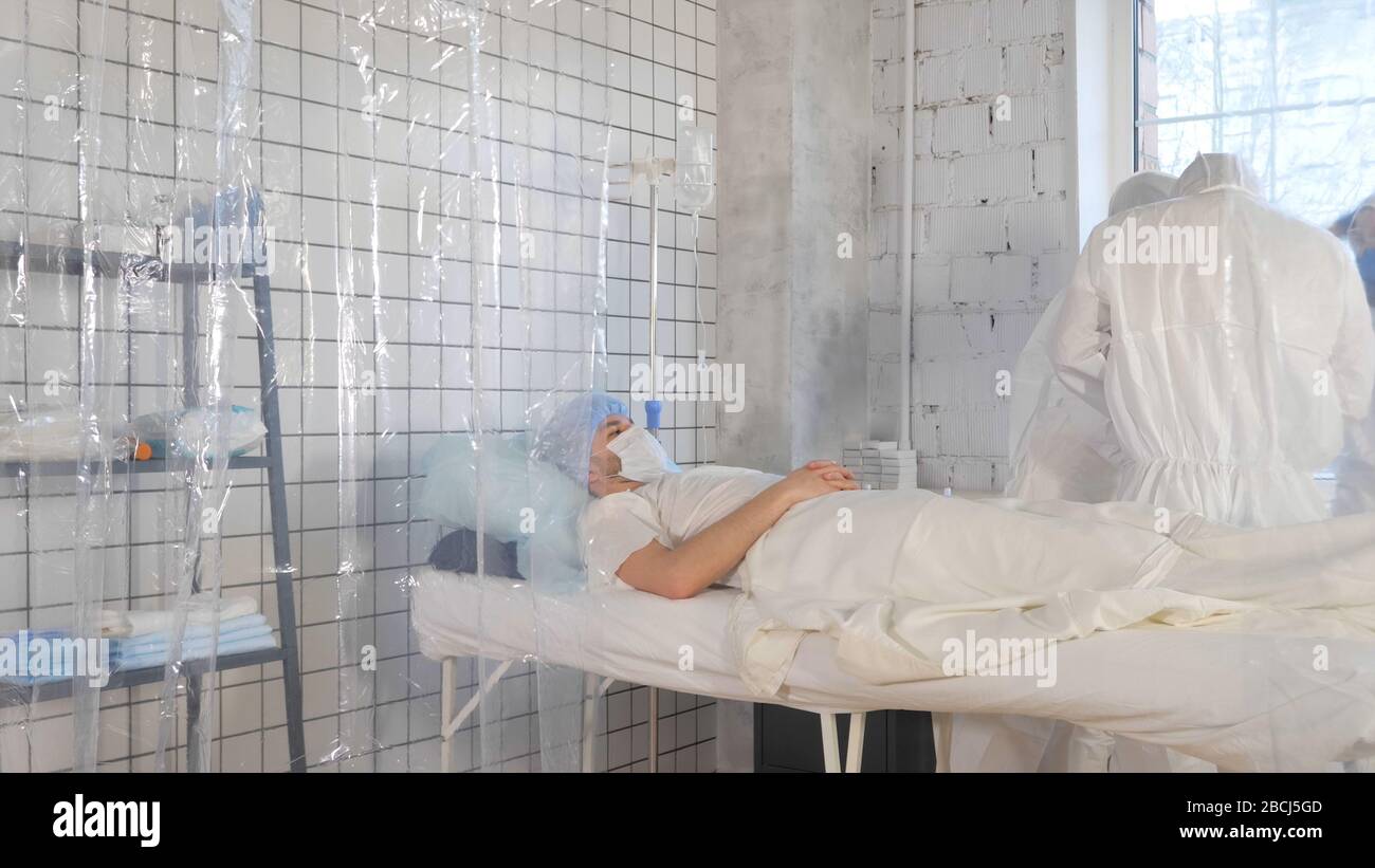 Patient in a hospital. Doctors in Hazmat Sterile Suit Stock Photo - Alamy