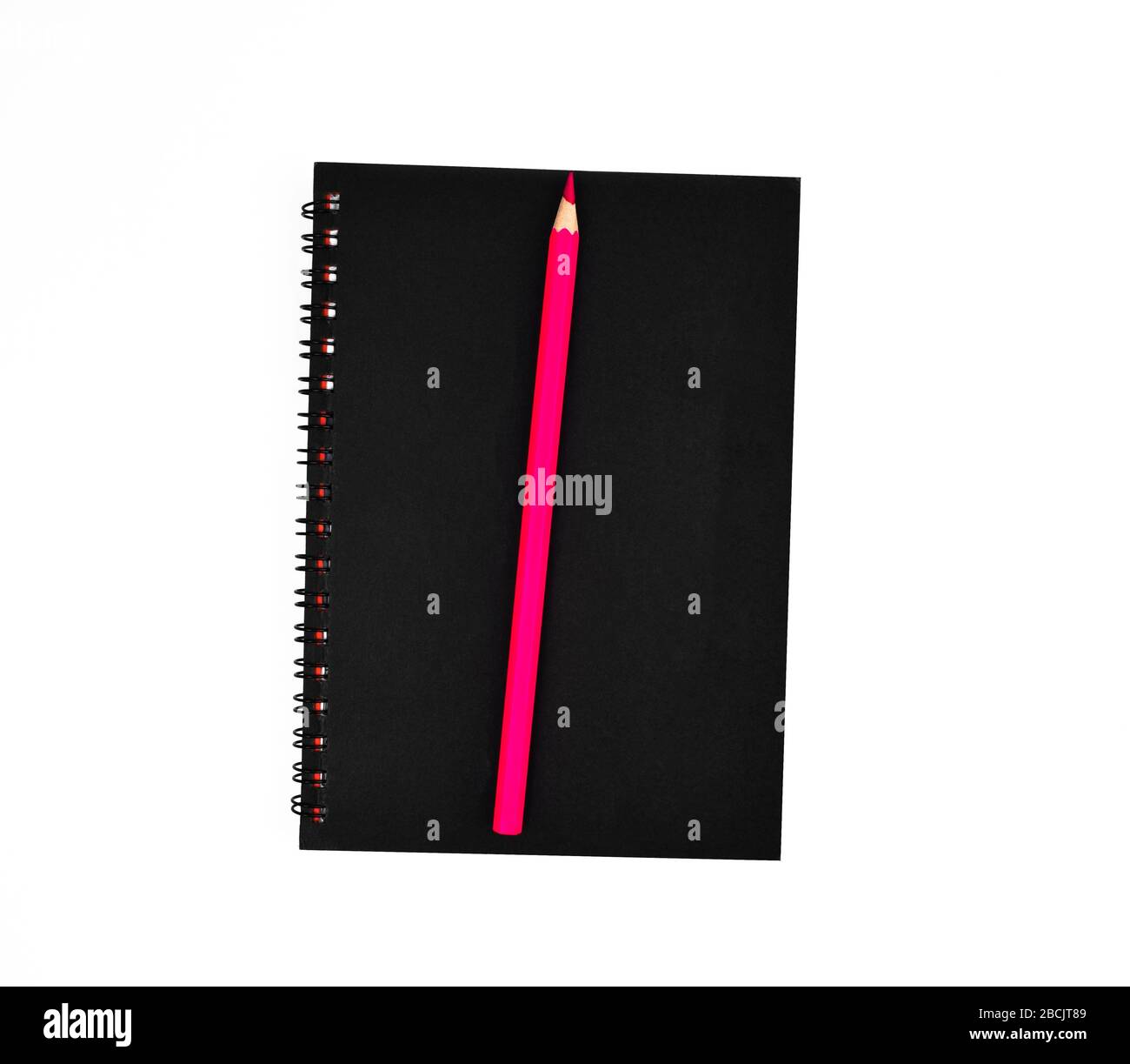 Pink pencil on top of a black color covered single note paper diary ...