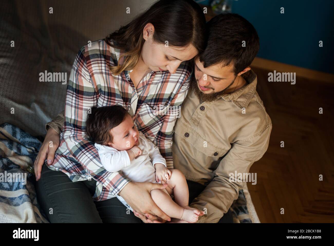 Lovely family of young parents and baby at home. Family, childhood and ...