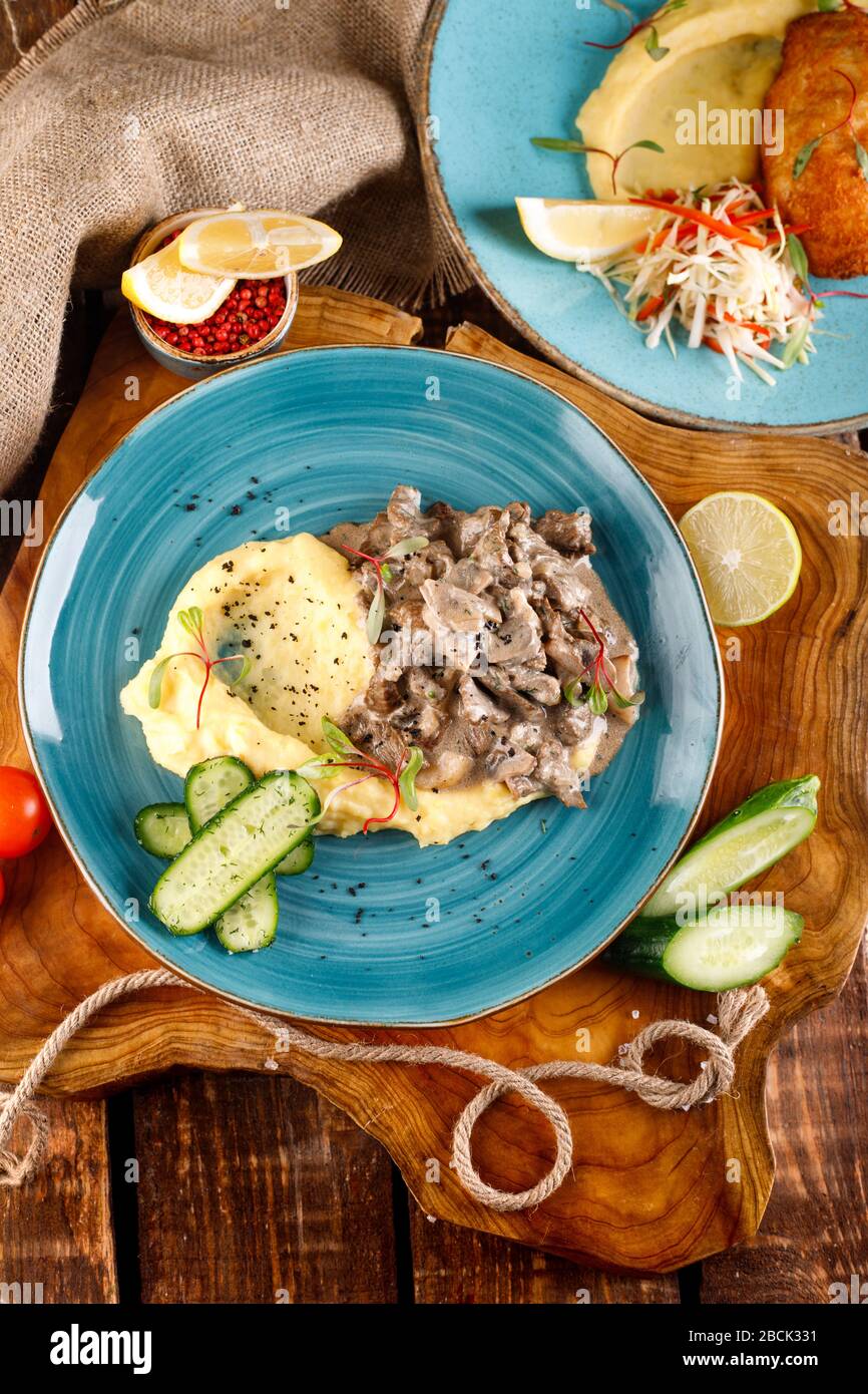 meat goulash is served with mashed potatoes and vegetables on a ...