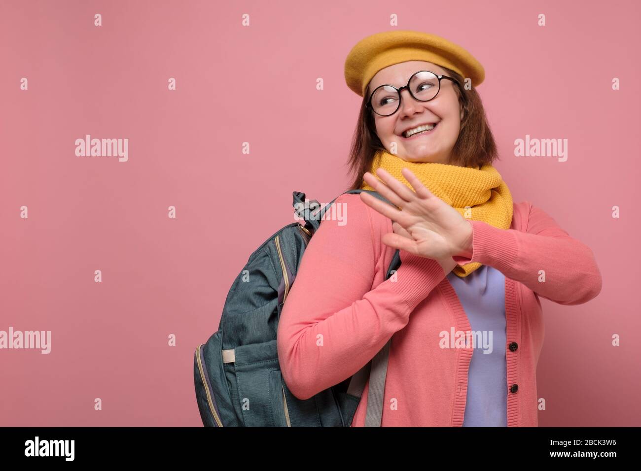 Young caucasian woman waving hand saying bye to her friends standing ...