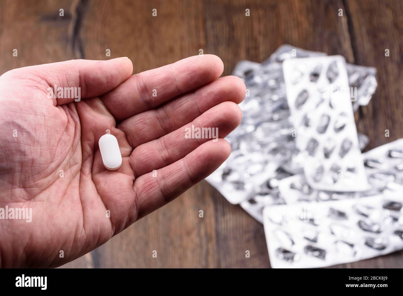 Human palm with a tablet on the background of empty blisters. Medical ...