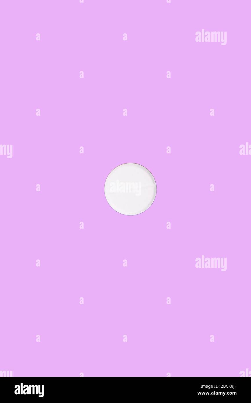 Round medical pill with a dividing notch on a pink background. Flat lay ...