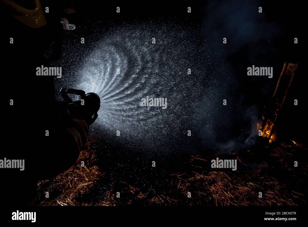 Firefighting group in action battling flames during night time Stock ...