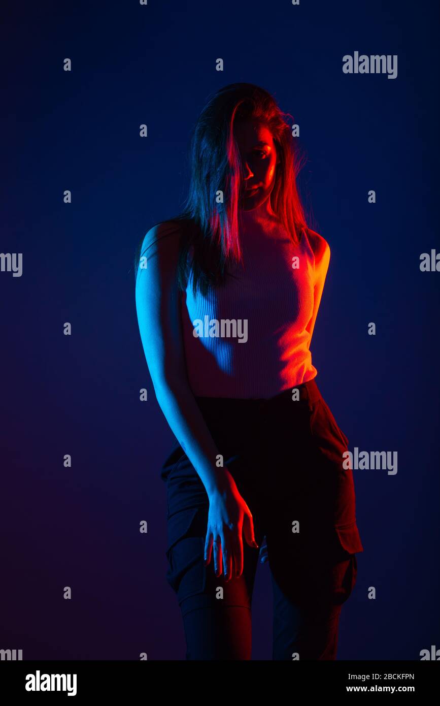 Female model posing in studio with red and blue colors at high contrast ...