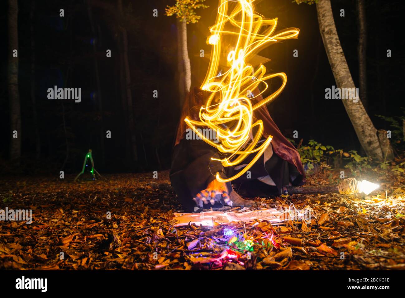 Wizard (mage) casting a spell with his magical staff while standing in ...
